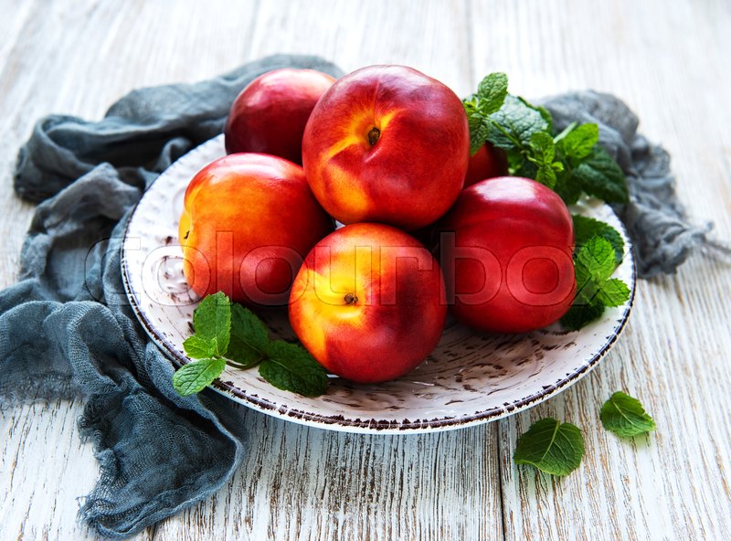 Plate with fresh nectarines on a white ... | Stock image | Colourbox