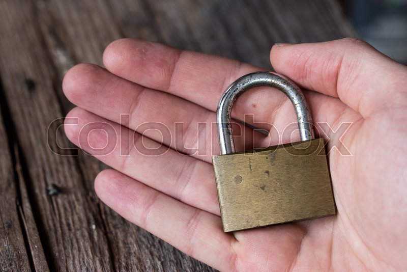 Padlock in the hand of a young man, ... | Stock image | Colourbox