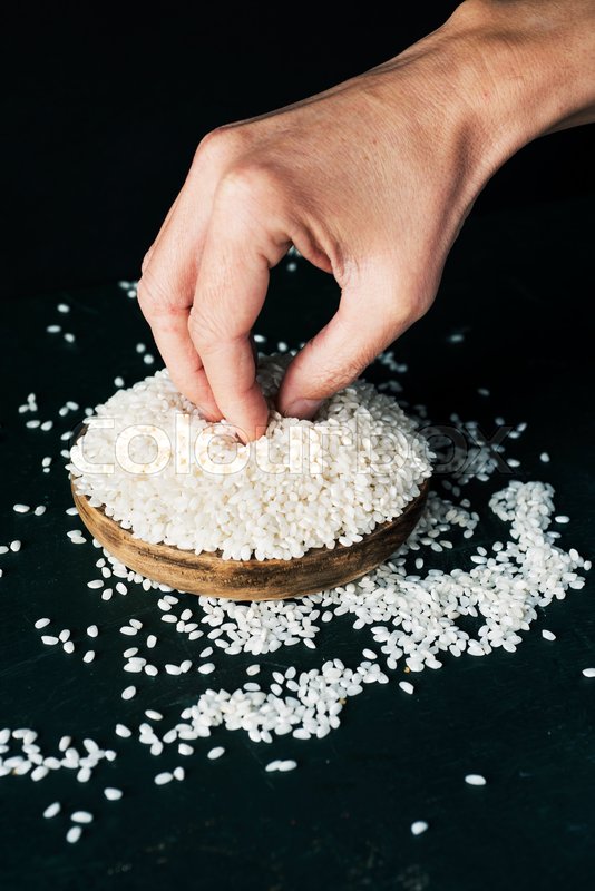 Closeup of a man grabbing some rice ... | Stock image | Colourbox