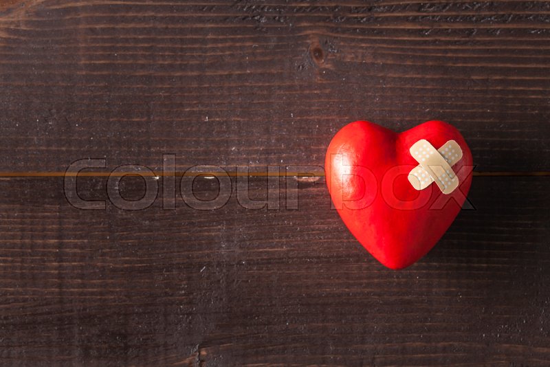 Red broken heart with a band-aid on a ... | Stock image | Colourbox