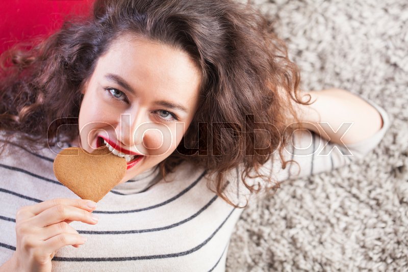 Cheerful attractive young woman eating ... | Stock image | Colourbox