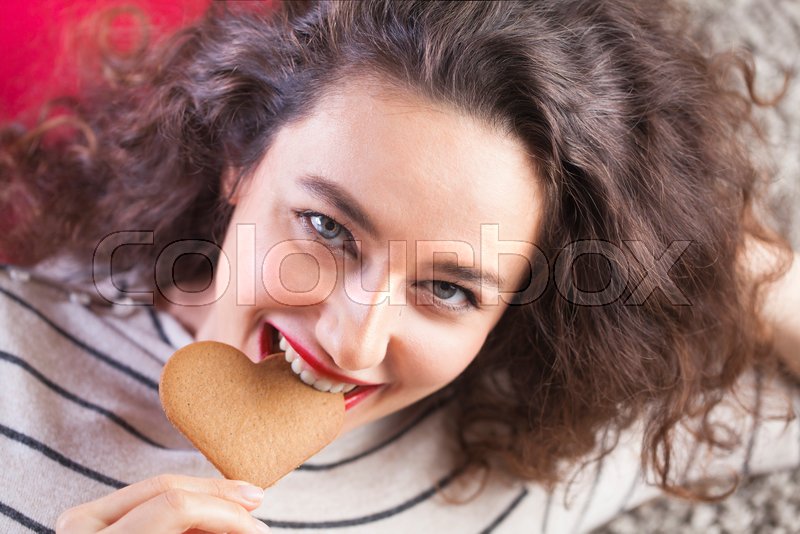 Cheerful attractive young woman eating ... | Stock image | Colourbox