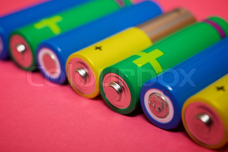 Small batteries on a pink table. | Stock image | Colourbox