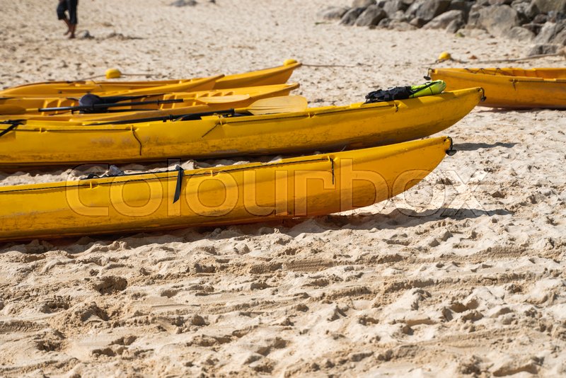 A row of colorful yellow kayaks on a ... | Stock image | Colourbox