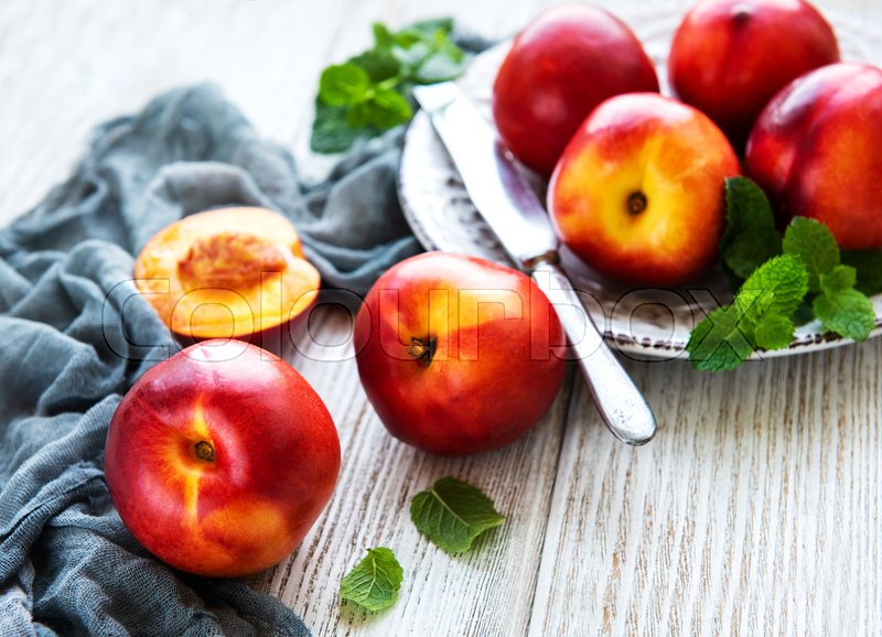 Plate with fresh nectarines on a white ... | Stock image | Colourbox