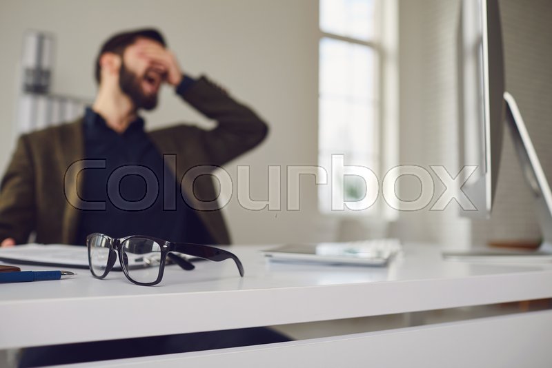 Exhausted tired worker at the workplace ... | Stock image | Colourbox