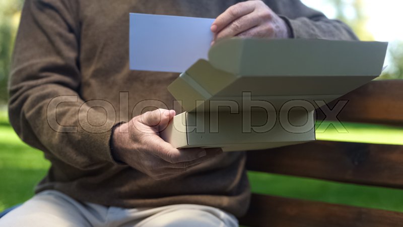 Old man opening carton box and looking ... | Stock image | Colourbox