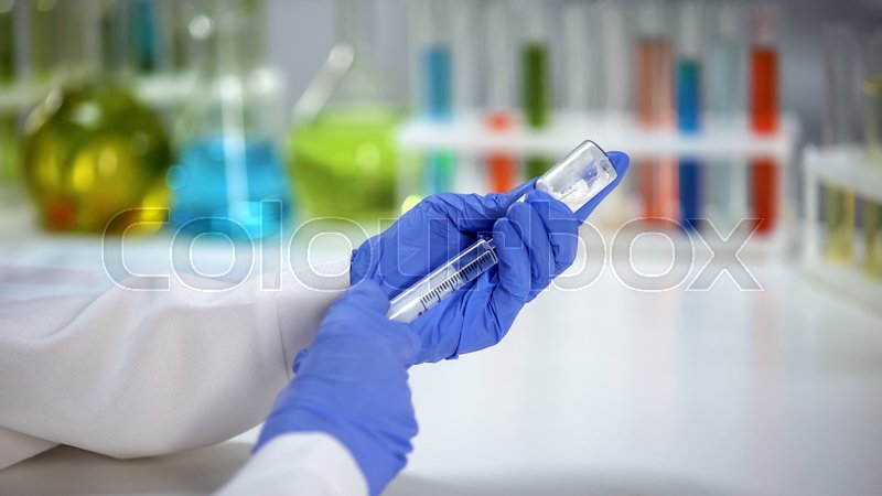 Researcher injecting liquid to tube ... | Stock image | Colourbox