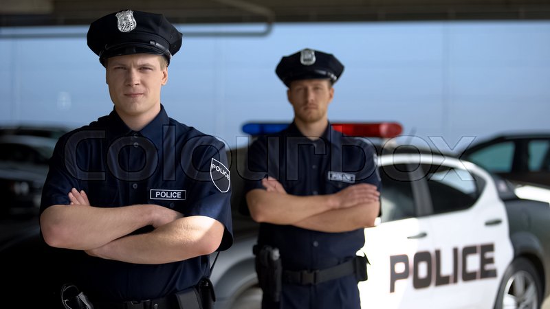 Serious male officers standing with ... | Stock image | Colourbox