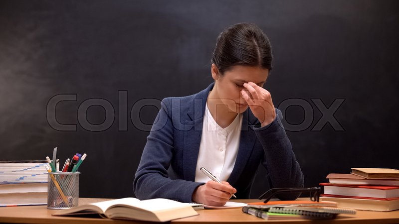 Lady teacher checking assignments and ... | Stock image | Colourbox