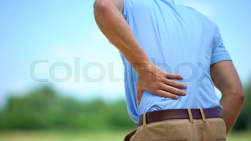 Male feeling sharp lower back pain ... | Stock image | Colourbox