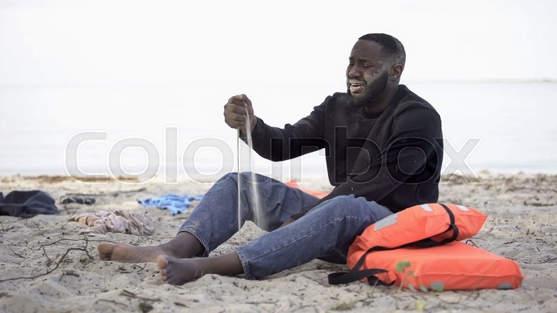 Desperate black man crying on shore, ... | Stock image | Colourbox