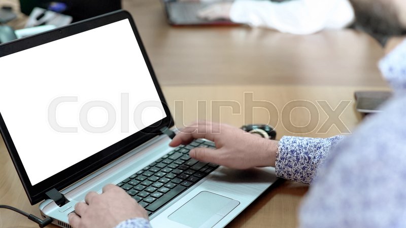 Male employee working on laptop at ... | Stock image | Colourbox