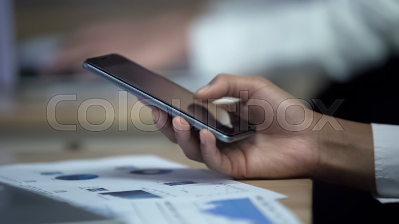 Office worker using smartphone while ... | Stock image | Colourbox