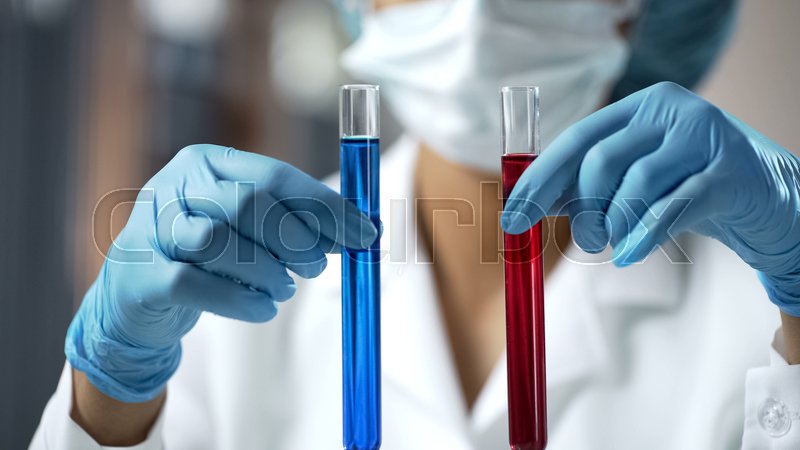Scientist holding two test tubes with ... | Stock image | Colourbox