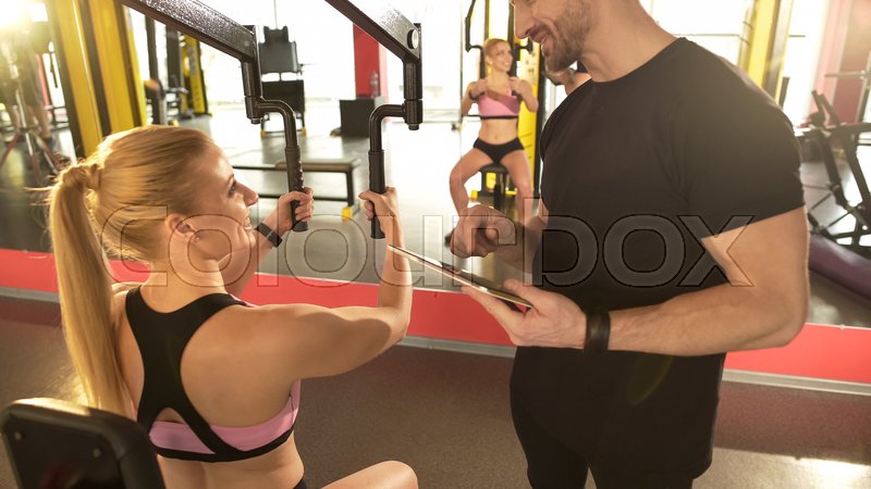 Training at gym, woman openly flirting ... | Stock image | Colourbox