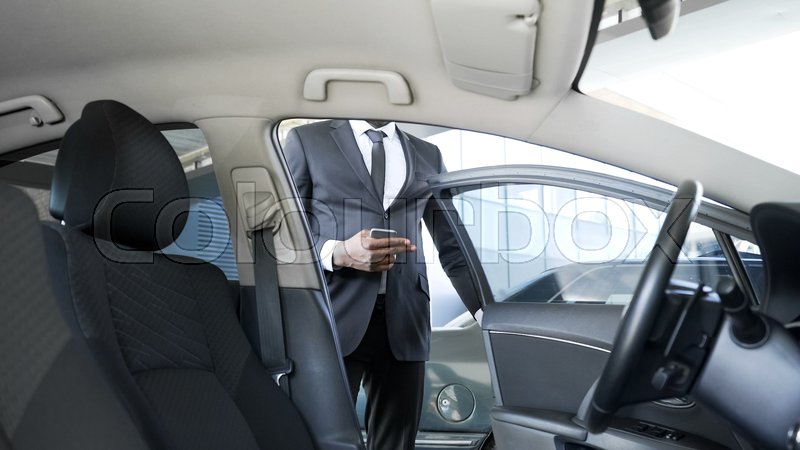 Busy man in suit getting in car, ... | Stock image | Colourbox