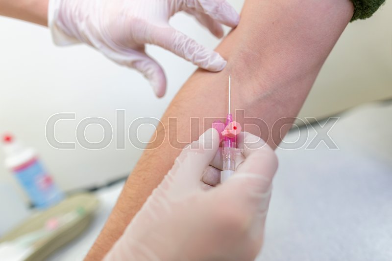 Doctor injects an infusion needle into ... | Stock image | Colourbox