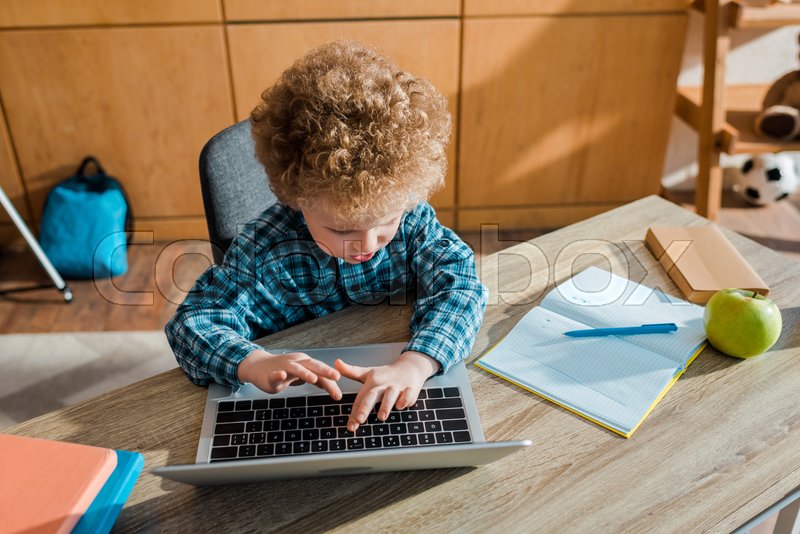 Overhead view of cute kid typing on ... | Stock image | Colourbox