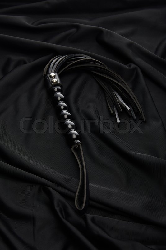 Leather flogging whip on black textile ... | Stock image | Colourbox