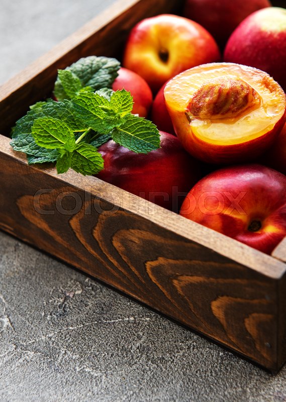 Box with fresh nectarines on a stone ... | Stock image | Colourbox