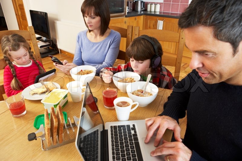 Family Using Gadgets Whilst Eating ... | Stock image | Colourbox