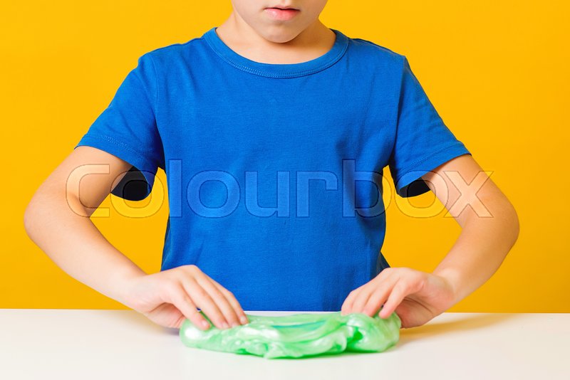 Cute boy playing with slime on a white ... | Stock image | Colourbox