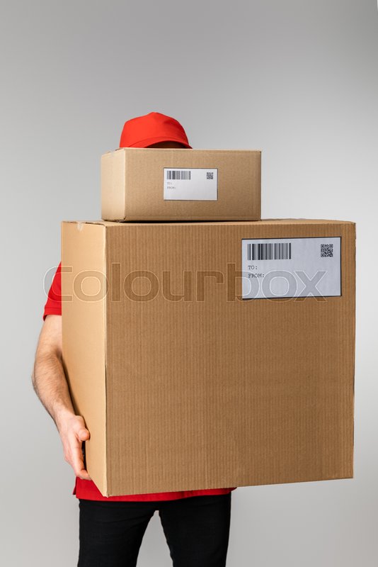 Courier in uniform holding boxes with ... | Stock image | Colourbox