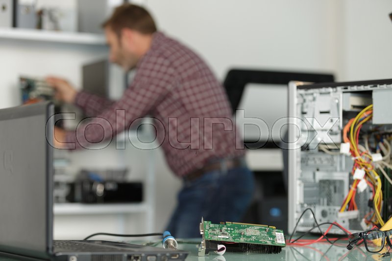 Frustrated young man fixing a pc | Stock image | Colourbox