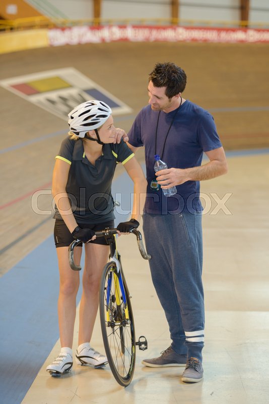 Coach and female cyclist in a velodrome | Stock image | Colourbox
