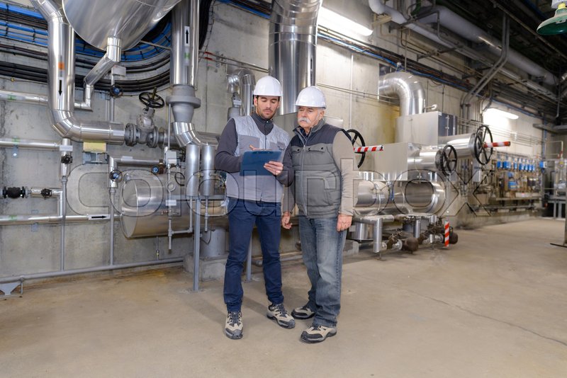 Workers next to pipes in the factory | Stock image | Colourbox