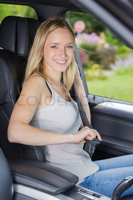 Attractive young woman fastening her ... | Stock image | Colourbox