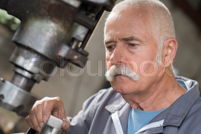 A senior worker using machinery | Stock image | Colourbox