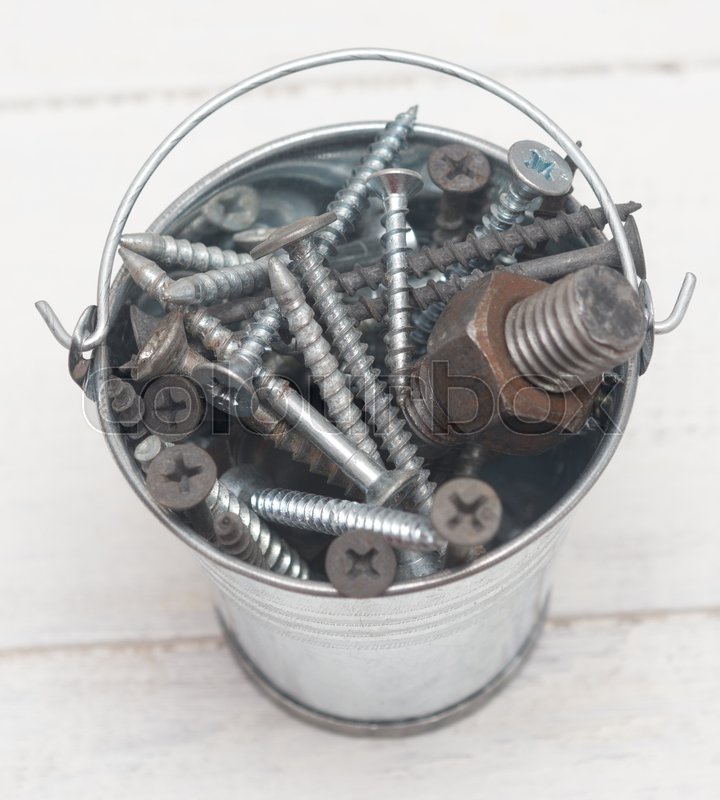 Screws and bolts in a bucket on a ... | Stock image | Colourbox
