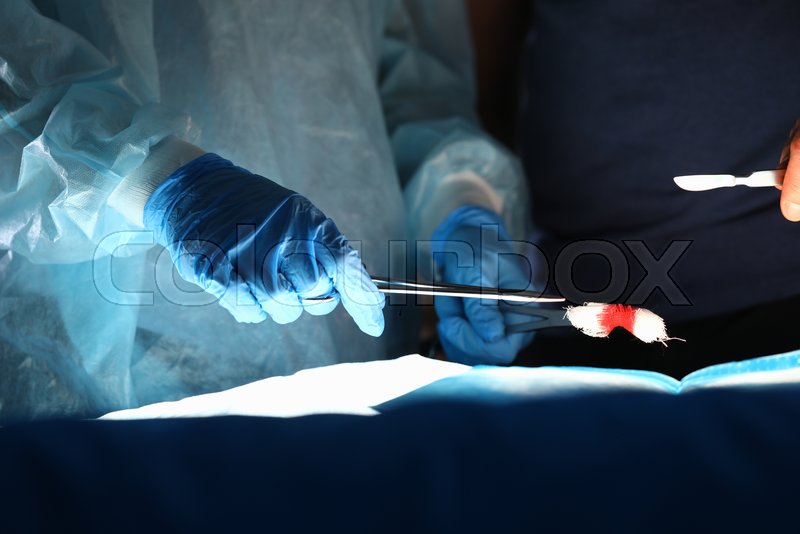 Surgeon in uniform holds blood-soaked ... | Stock image | Colourbox