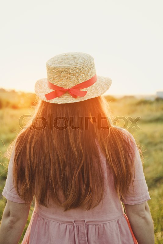 Young girl back up in a straw hat with ... | Stock image | Colourbox