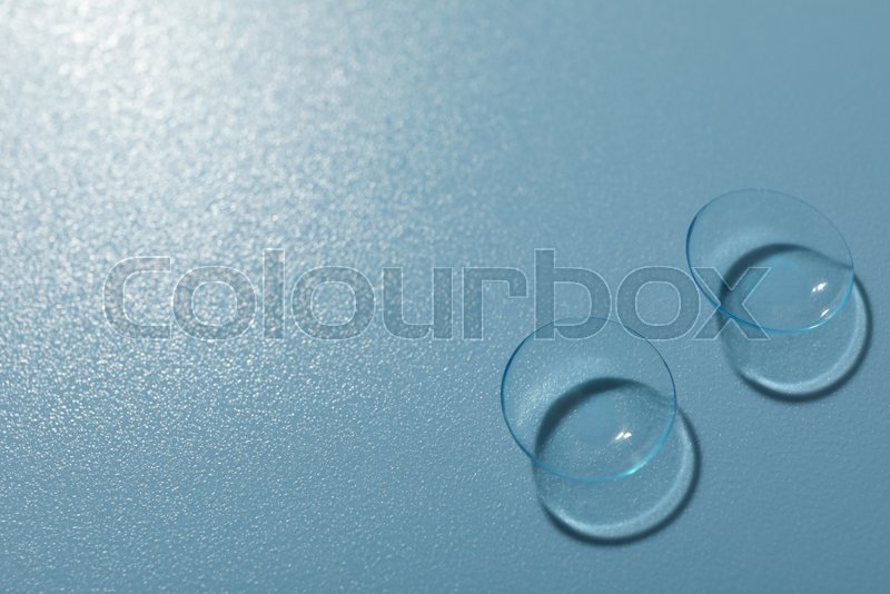 Contact lenses on blue background, ... | Stock image | Colourbox