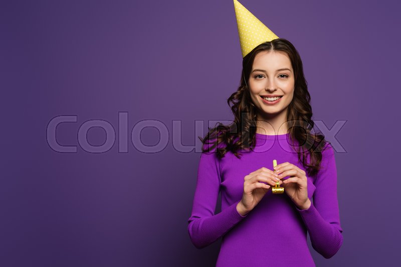 Happy girl in party cap holding party ... | Stock image | Colourbox
