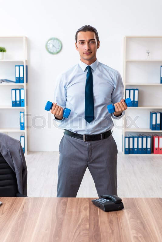 The young handsome employee doing sport ... | Stock image | Colourbox