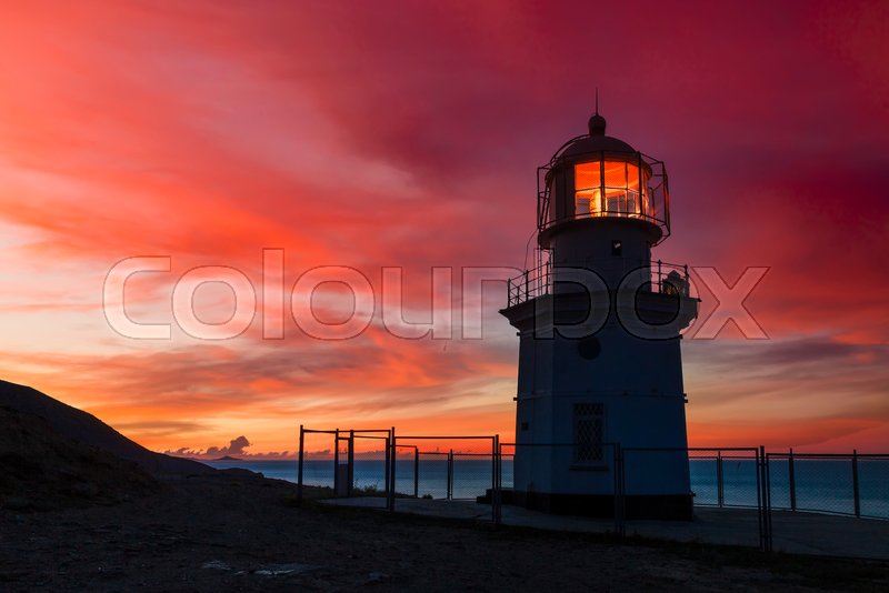 Lighthouse at sunset on the ocean. ... | Stock image | Colourbox