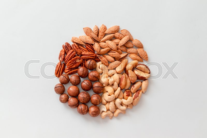 Assorted brown nuts circle on a gray ... | Stock image | Colourbox