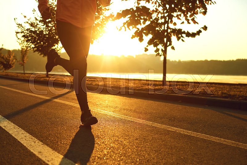 Runner runs on the road in the sun at ... | Stock image | Colourbox