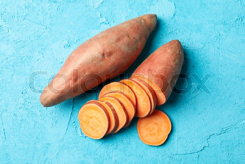 Sweet potato on blue background, close ... | Stock image | Colourbox