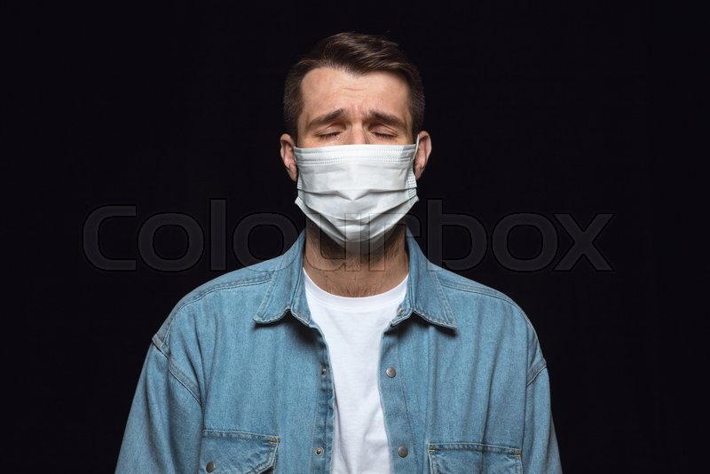 Crying man in protective mask on black ... | Stock image | Colourbox