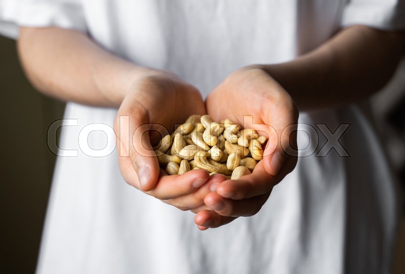 Cashew nuts in a womans hands. Cashew ... | Stock image | Colourbox