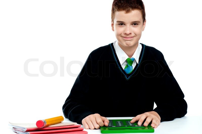 Smiling young boy using calculator | Stock image | Colourbox