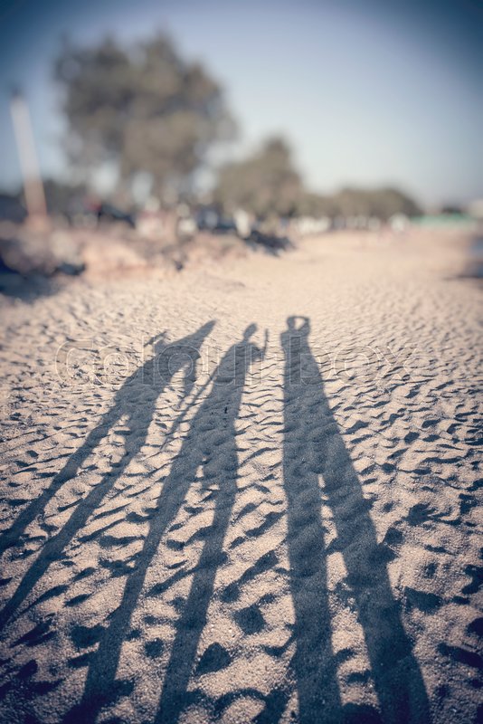 Shadows of three people on a beach in ... | Stock image | Colourbox