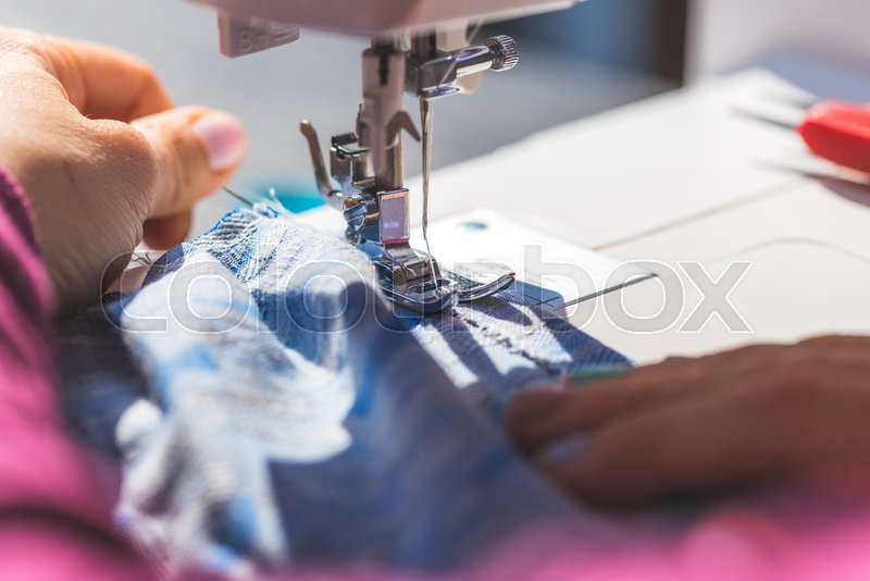 Sewing at home: Woman is sewing at ... | Stock image | Colourbox