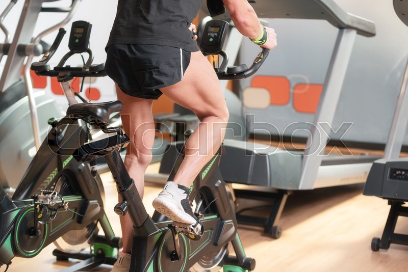 Muscular man biking in the gym, ... | Stock image | Colourbox