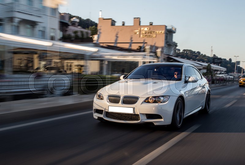White sedan driving on the central ... | Stock image | Colourbox